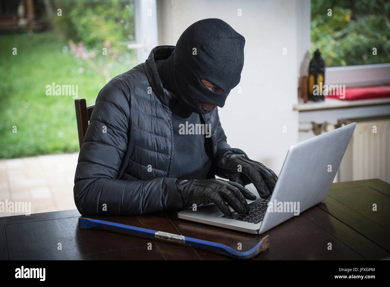 Thief hacker working on laptop and stealing data Stock Photo - Alamy