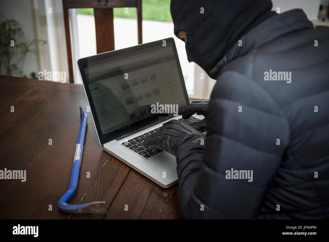 Thief hacker working on laptop and stealing data Stock Photo - Alamy