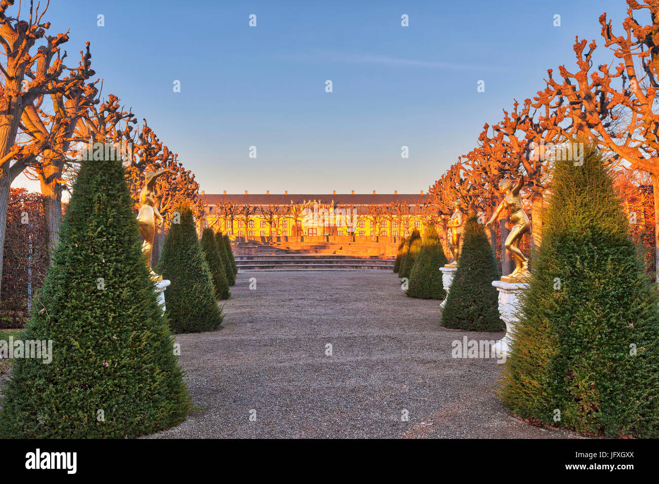 Cone-shaped trees with golden statues at Herrenhausen garden Stock ...