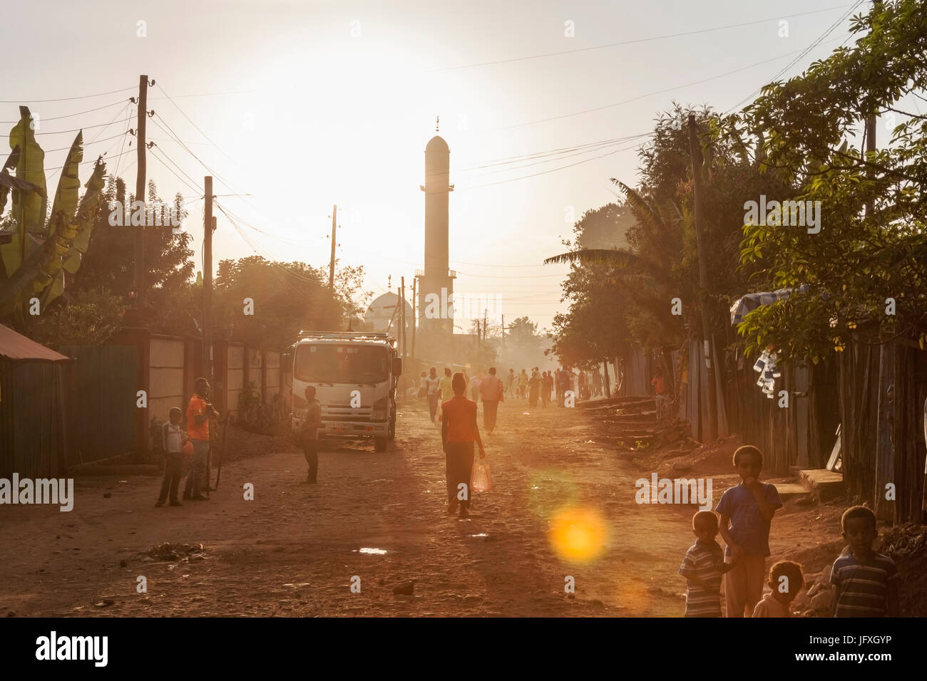 People walking on street with tall structure in background Stock Photo ...