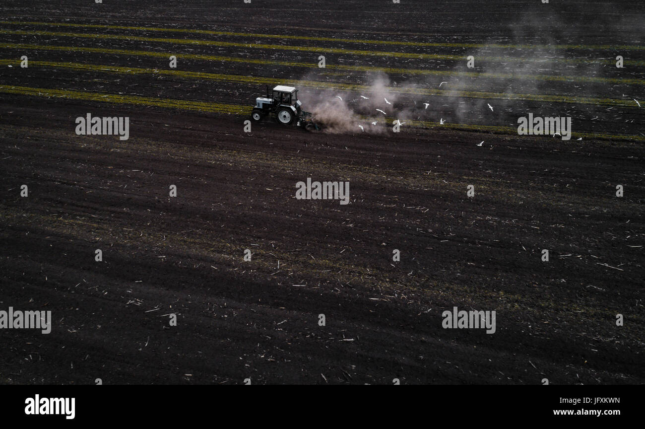 Tractor cultivating field at spring, aerial view Stock Photo - Alamy