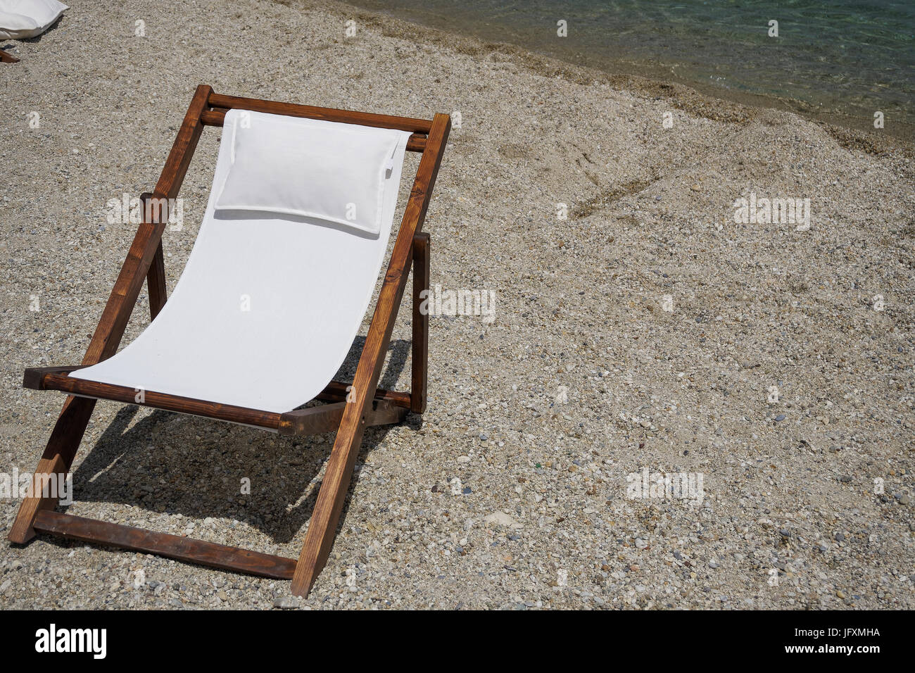Chaise longue deck beach chair with white texture seating on a hot ...