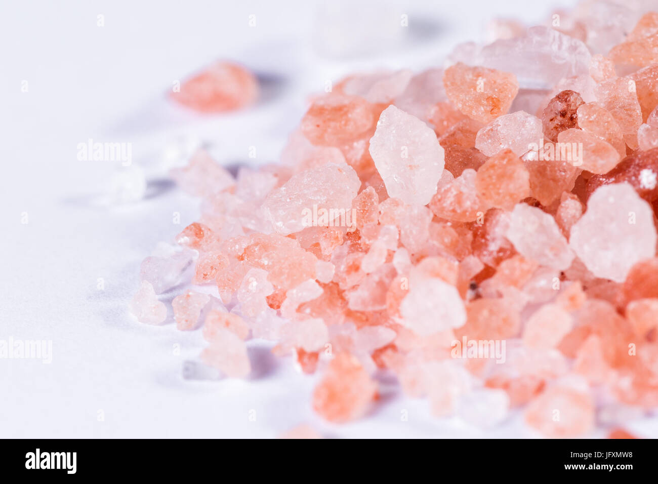 Himalayan pink salt crystals piled and isolated on a white background ...