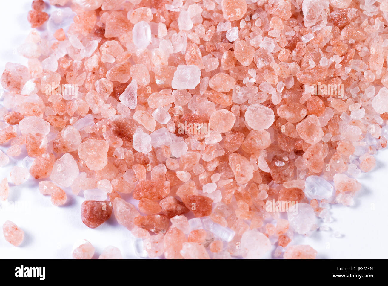 Himalayan pink salt crystals piled and isolated on a white background ...