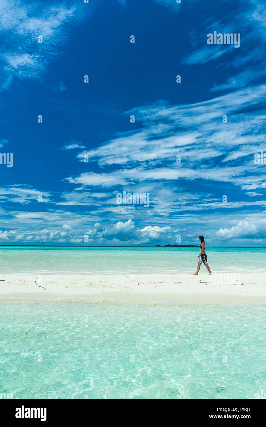 Tourist walking on a little sand strip appearing on low tide at Rock ...