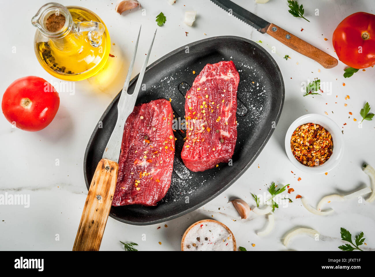 Meat, beef. Fresh raw steaks in a frying pan. Spices (salt, pepper ...