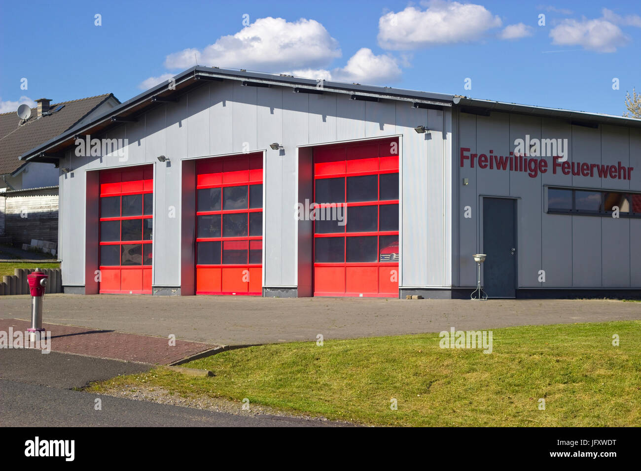 A small rural fire hall with red gates out in a country community in ...