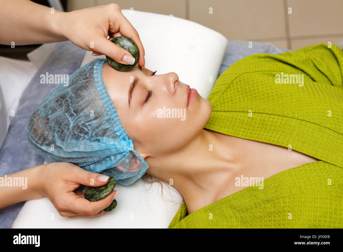 Spa treatment. Facial massage with jade stones. Alternative medicine ...