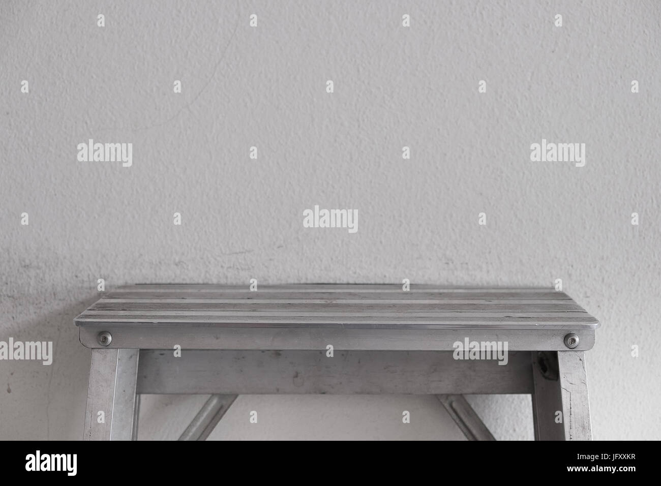 Aluminum ladder on the gray wall, room interior Stock Photo - Alamy