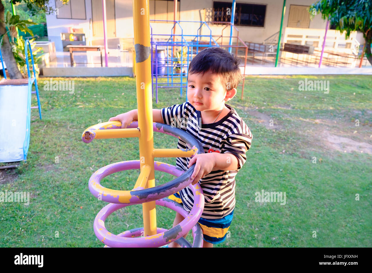 Active little child playing climbing spring metal at school yard ...