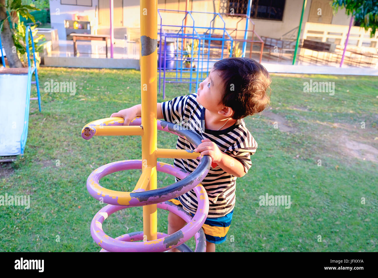 Active little child playing climbing spring metal at school yard ...