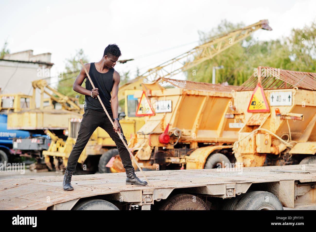 Portrait of an african american man using tools and equipment on the ...