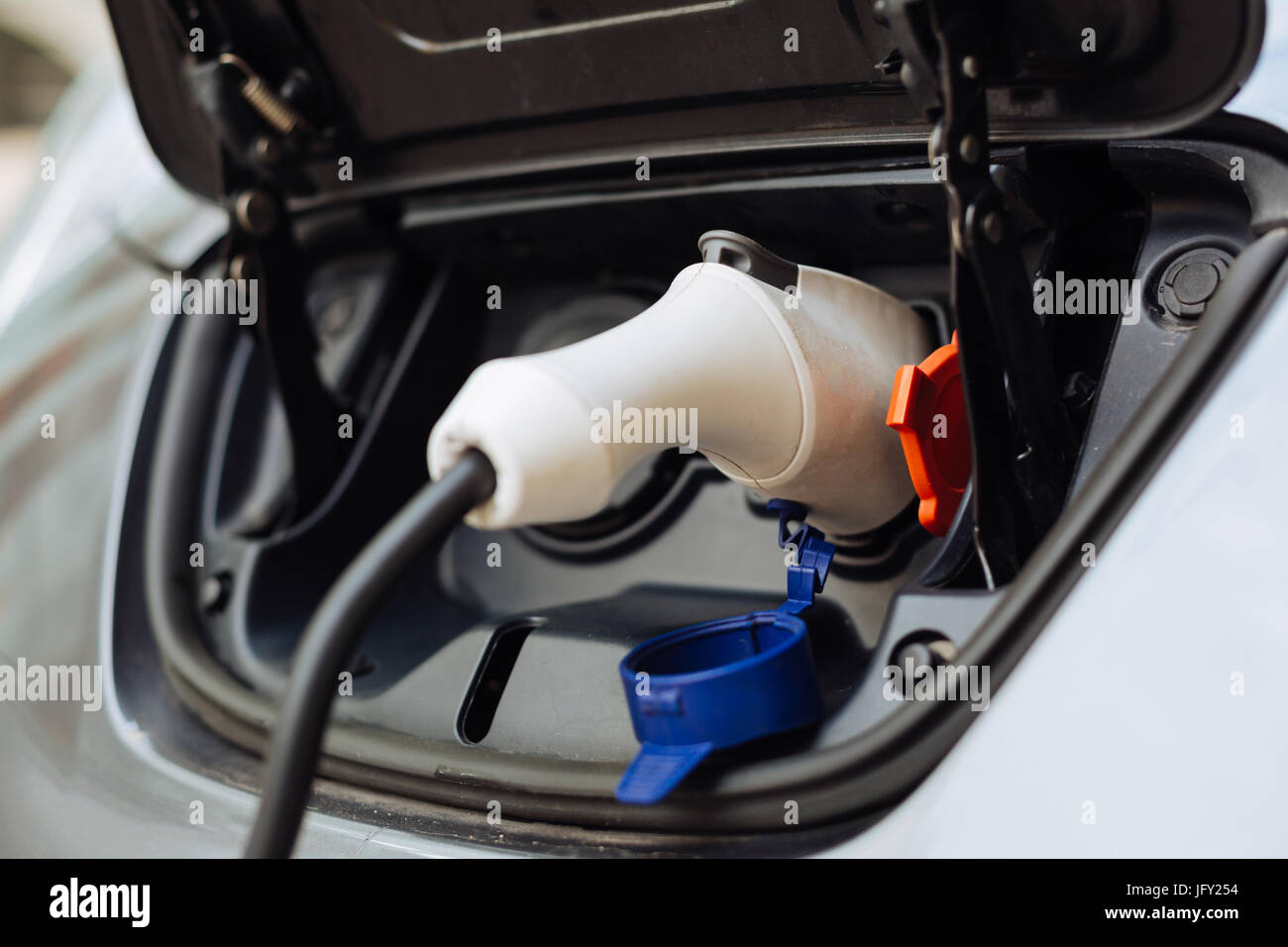 White electrical nozzle being plugged into e-car Stock Photo - Alamy