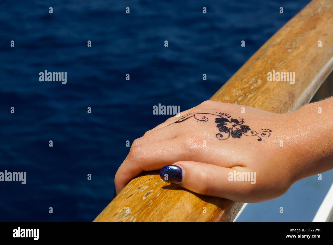 A photograph of a female hand holding onto the handrail of a boat in ...