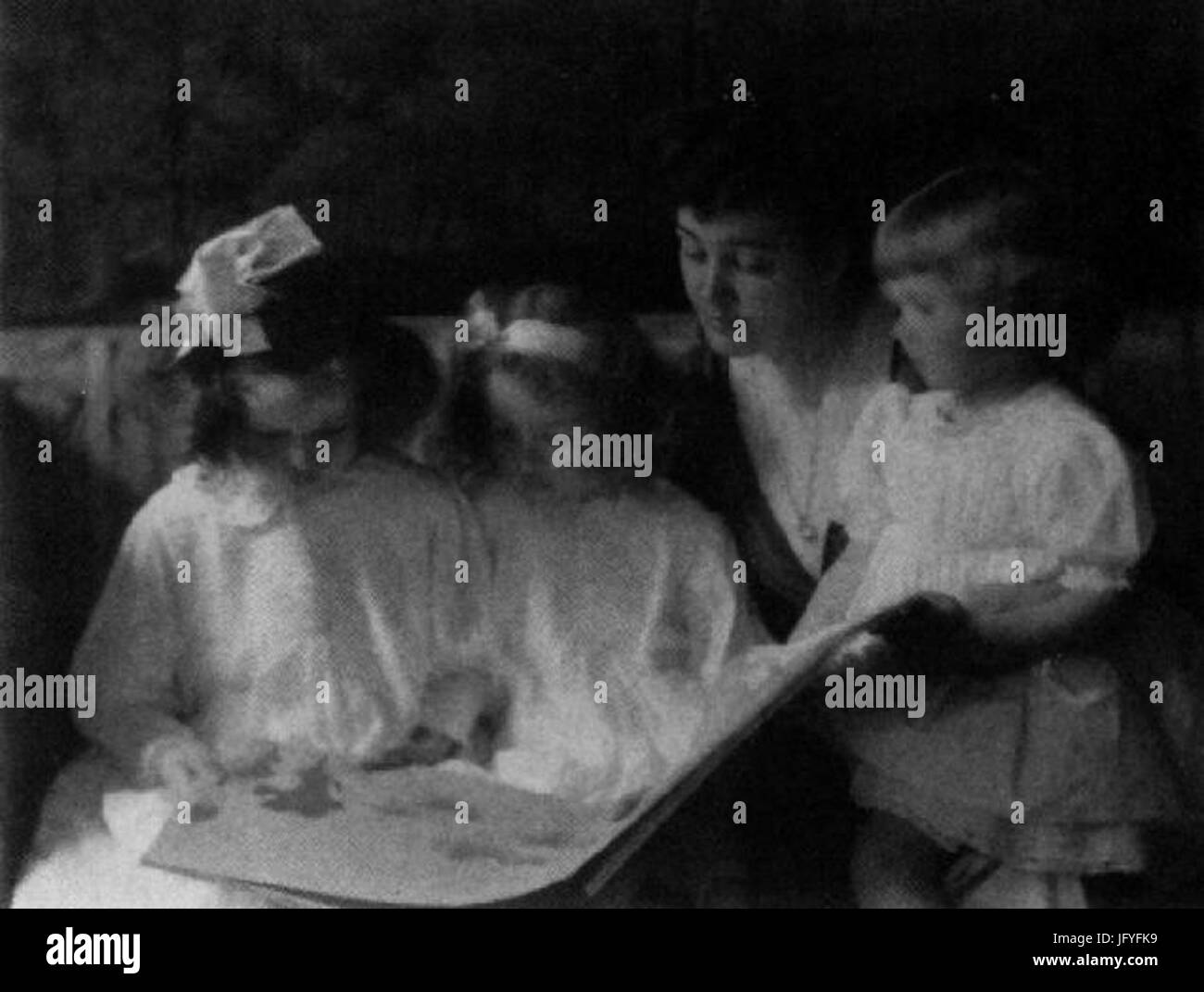 Eva Watson-Schütze Mother and children looking at an album Stock Photo ...