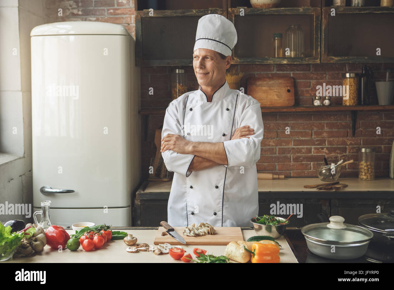 Mature male professional chef cooking meal indoors smiling Stock Photo ...