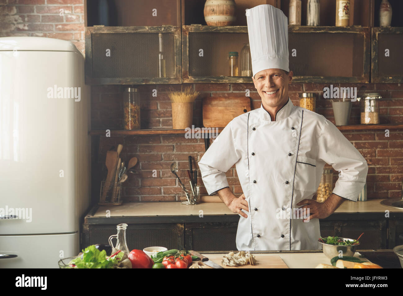 Mature male professional chef cooking meal indoors smiling Stock Photo ...