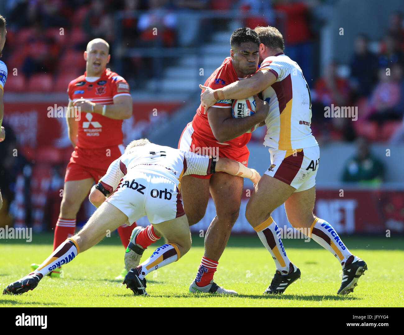 Salford Red Devils's Lama Tasi is tackled by Huddersfield Giants Ryan ...