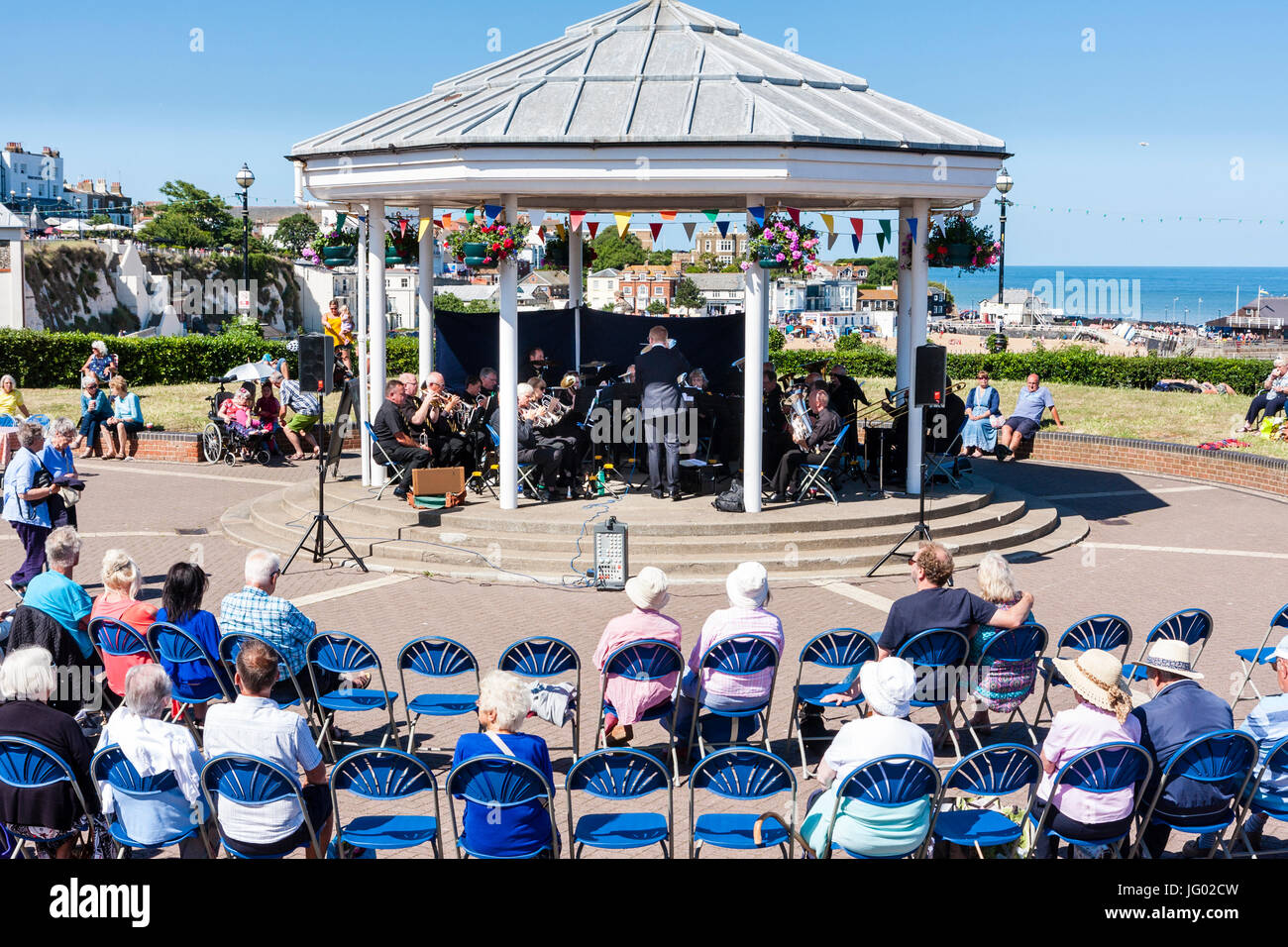People sitting around bandstand on Broadstairs seafront, watching the ...