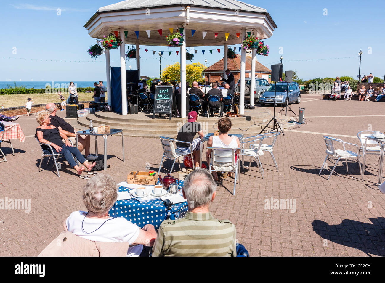 People sitting around bandstand on Broadstairs seafront, watching the ...