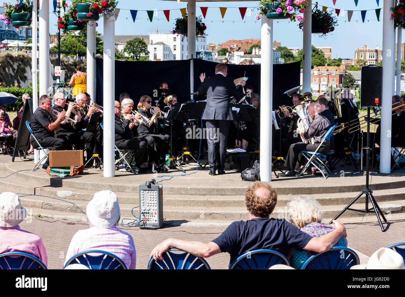 People sitting around bandstand on Broadstairs seafront, watching the ...
