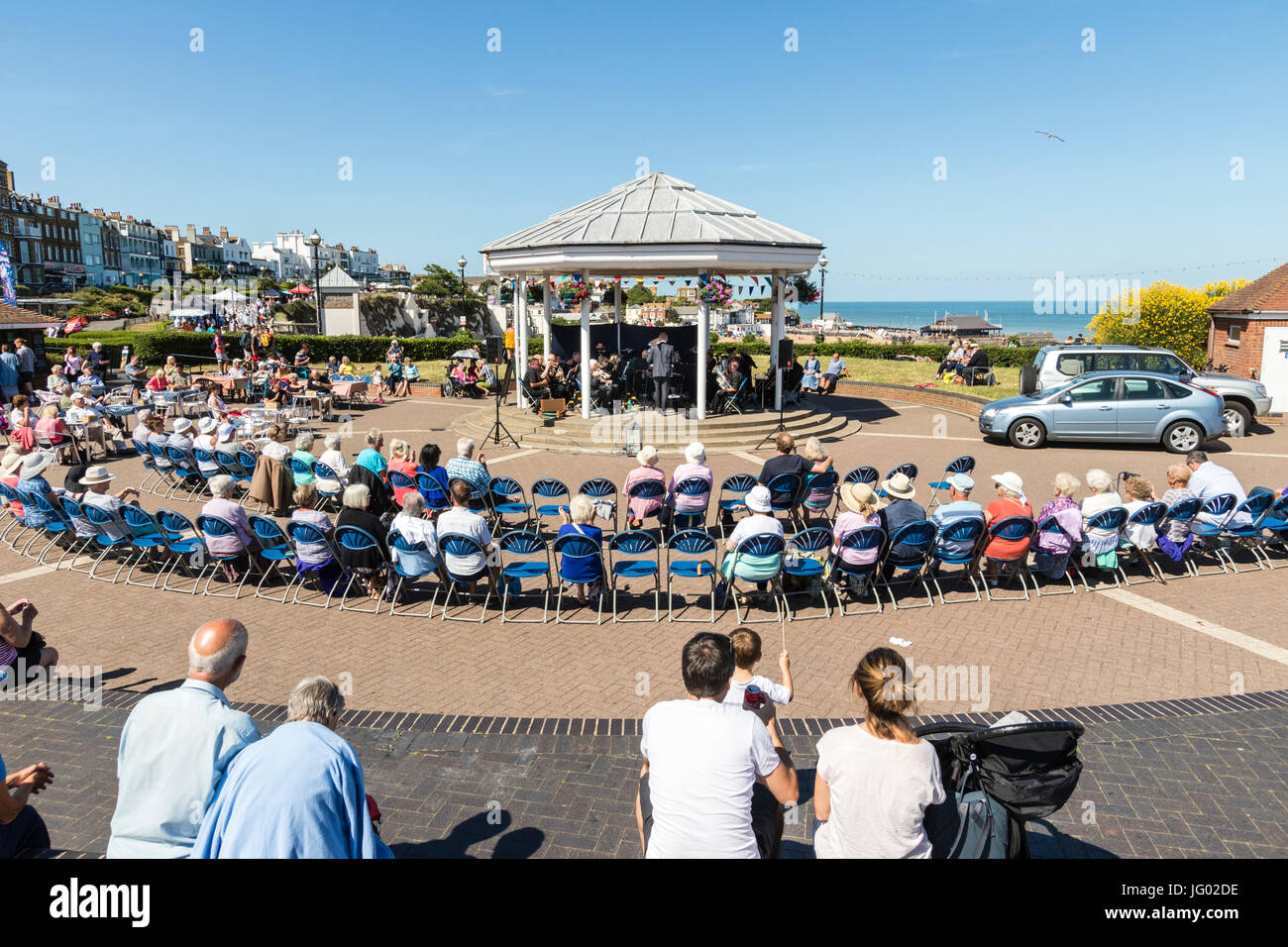 People sitting around bandstand on Broadstairs seafront, watching the ...