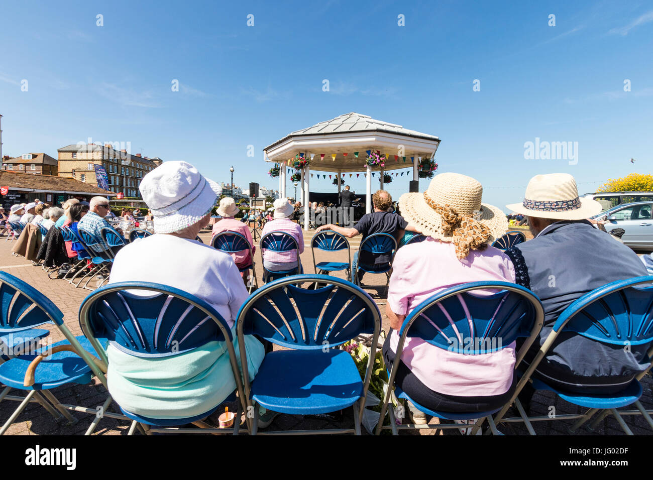 People sitting around bandstand on Broadstairs seafront, watching the ...