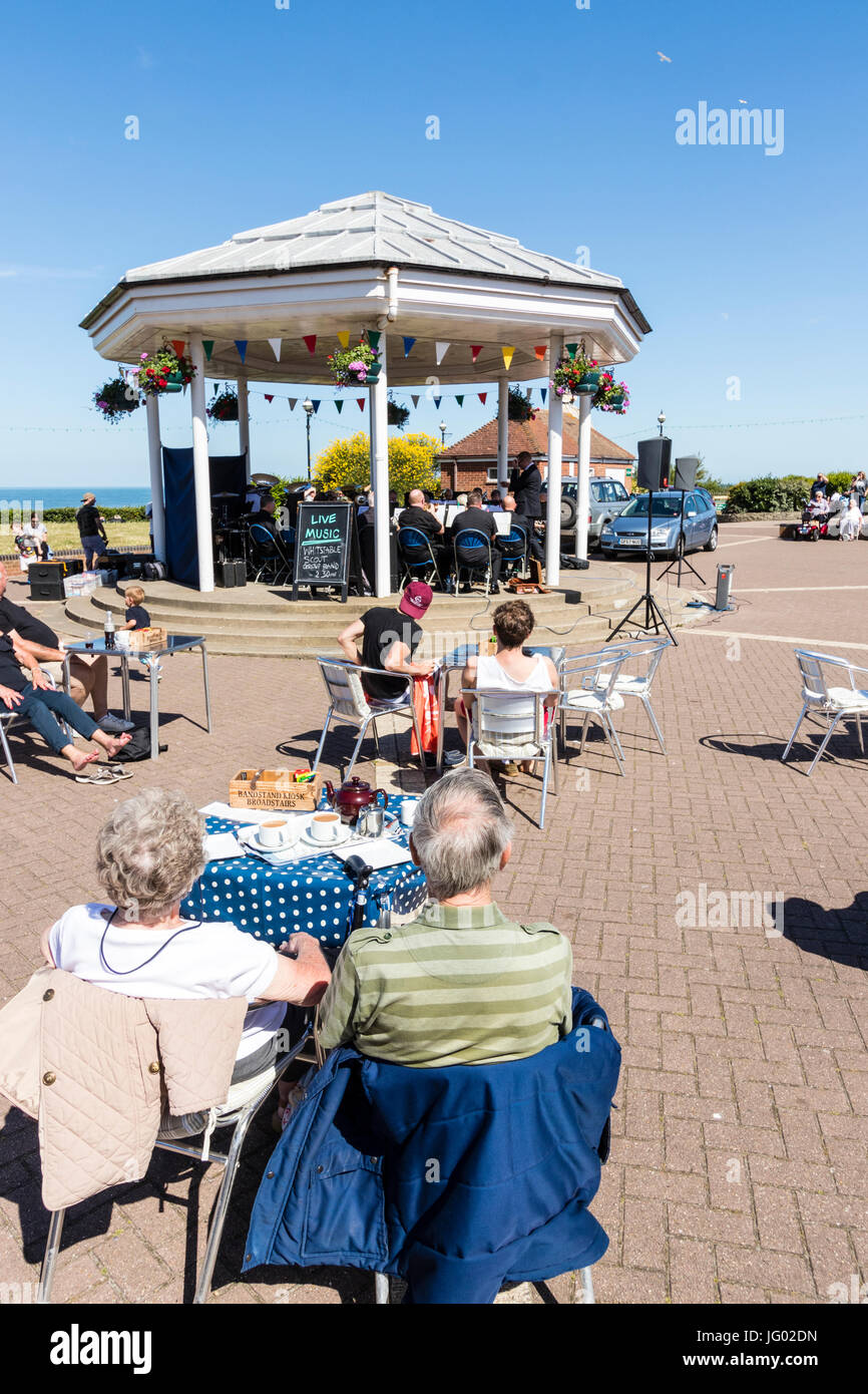 People sitting around bandstand on Broadstairs seafront, watching the ...