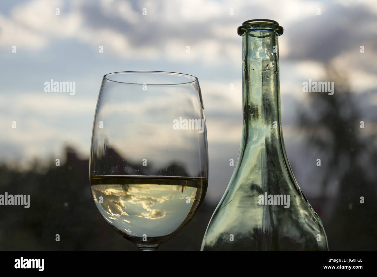 A glass of white wine and a bottle Stock Photo - Alamy