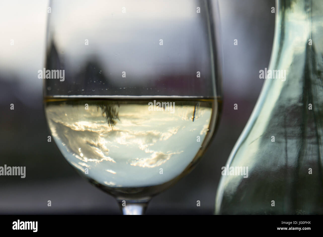 A glass of white wine and a bottle Stock Photo - Alamy