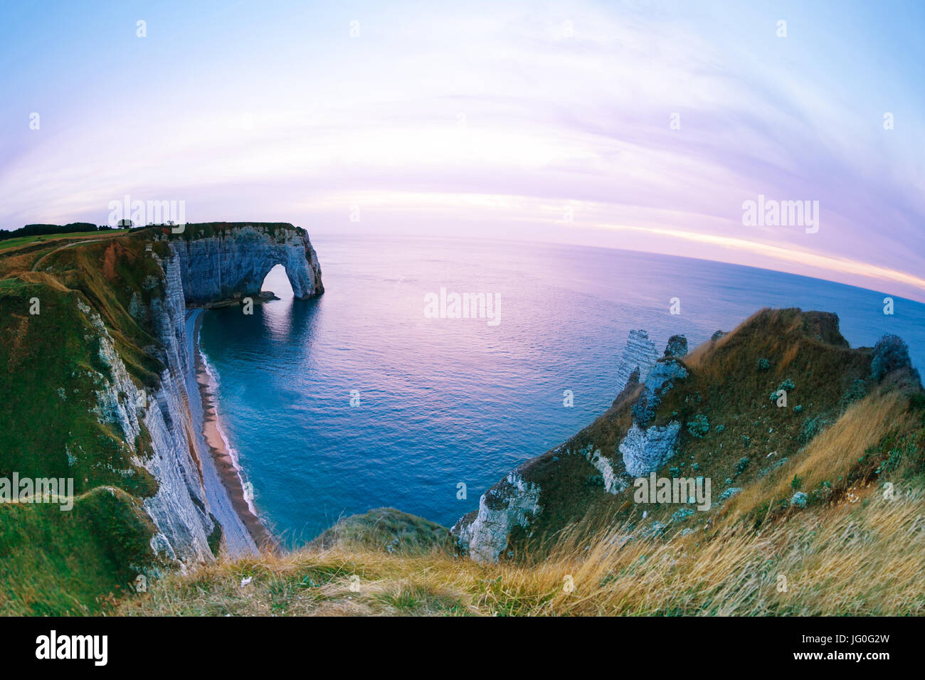 Scenic view of Etretat chalk cliffs with arch at sunset, Normandy ...