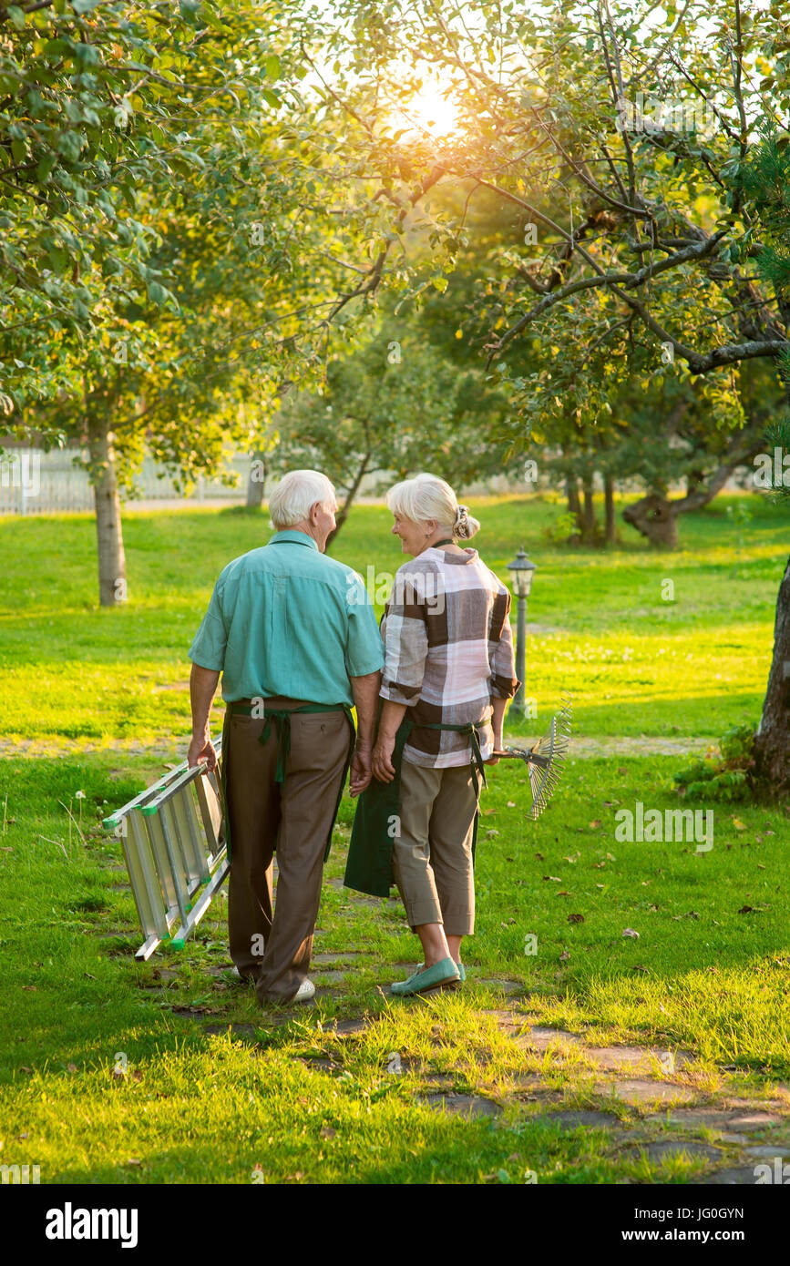 Elderly gardeners couple, back view Stock Photo - Alamy