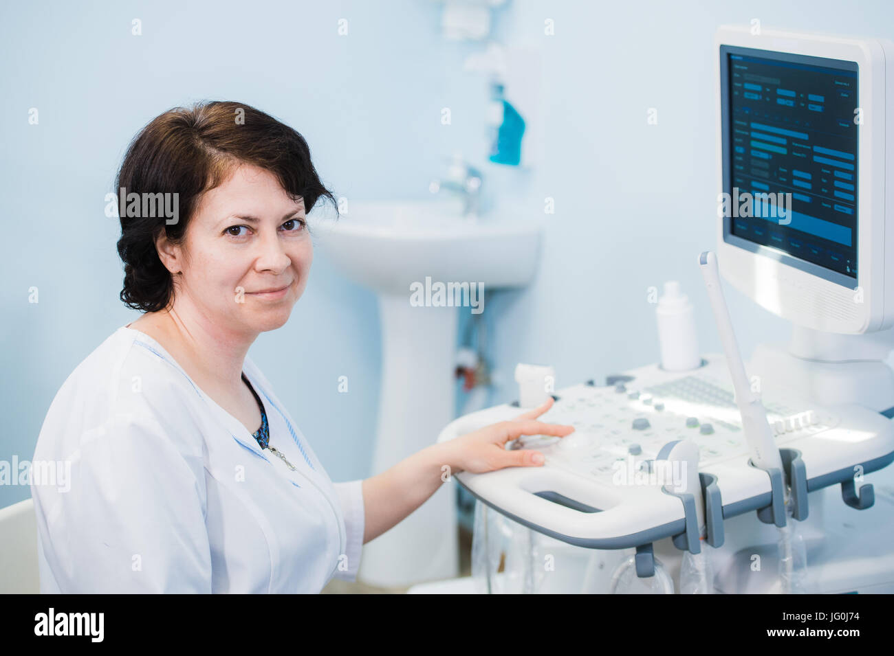 Happy mature female doctor using ultrasound scanner. Echography machine ...