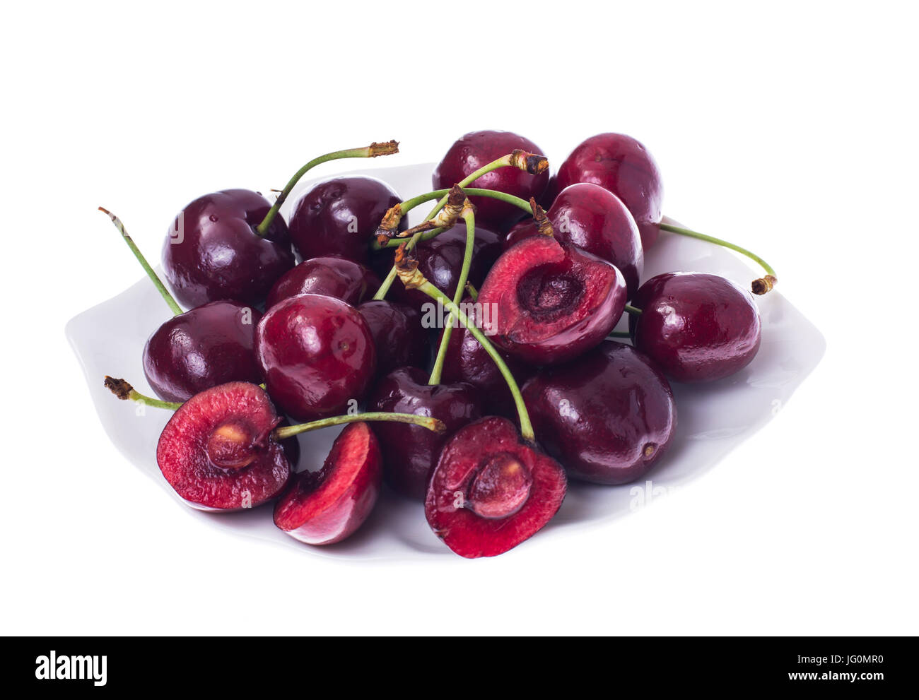 Whole and halves of ripe cherries on white plate. Studio Photo Stock ...