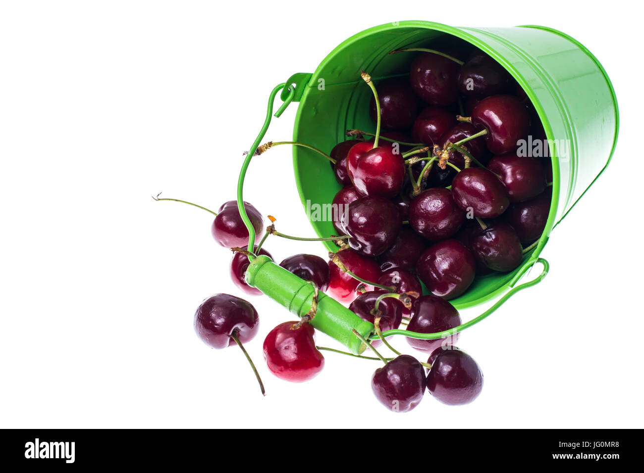 Cherry in an overturned green bucket. Studio Photo Stock Photo - Alamy
