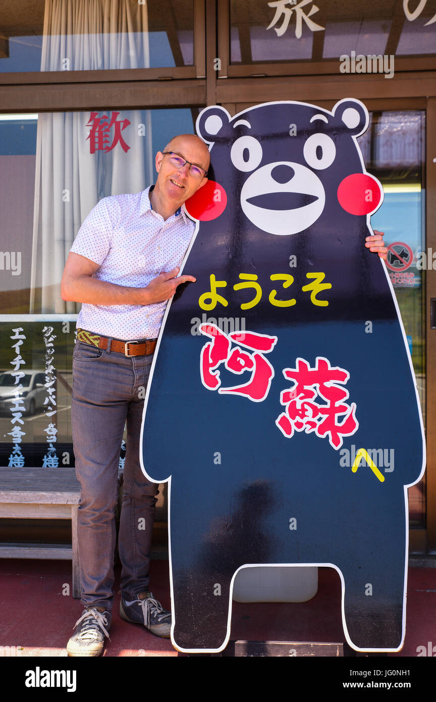 European man with Cardboard cut-out of Kumamon bear, Mount Aso, Kyushu ...