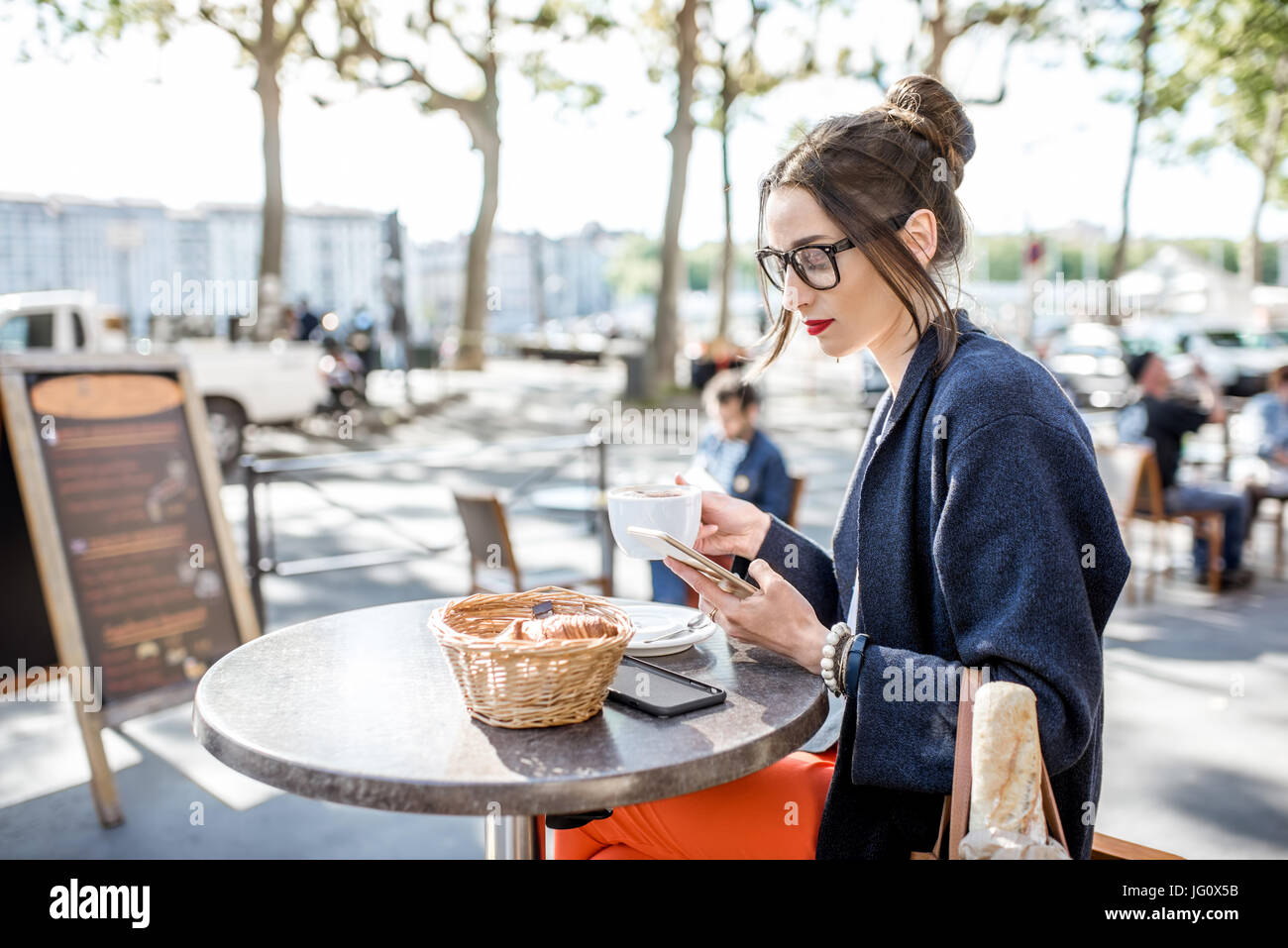 Woman sitting at the cafe outdoors Stock Photo - Alamy