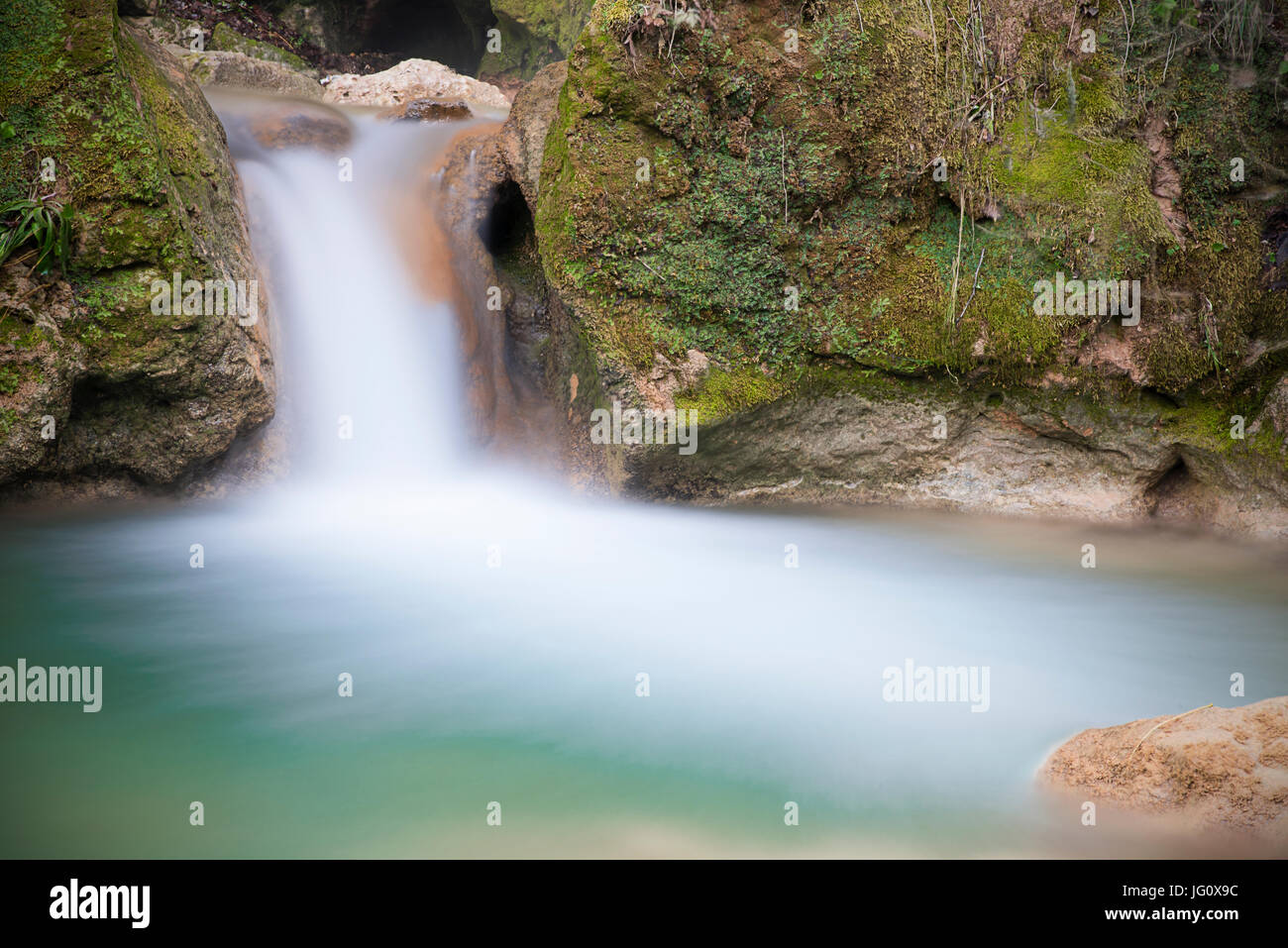 Waterfall among trees and moss covered rocks Stock Photo - Alamy