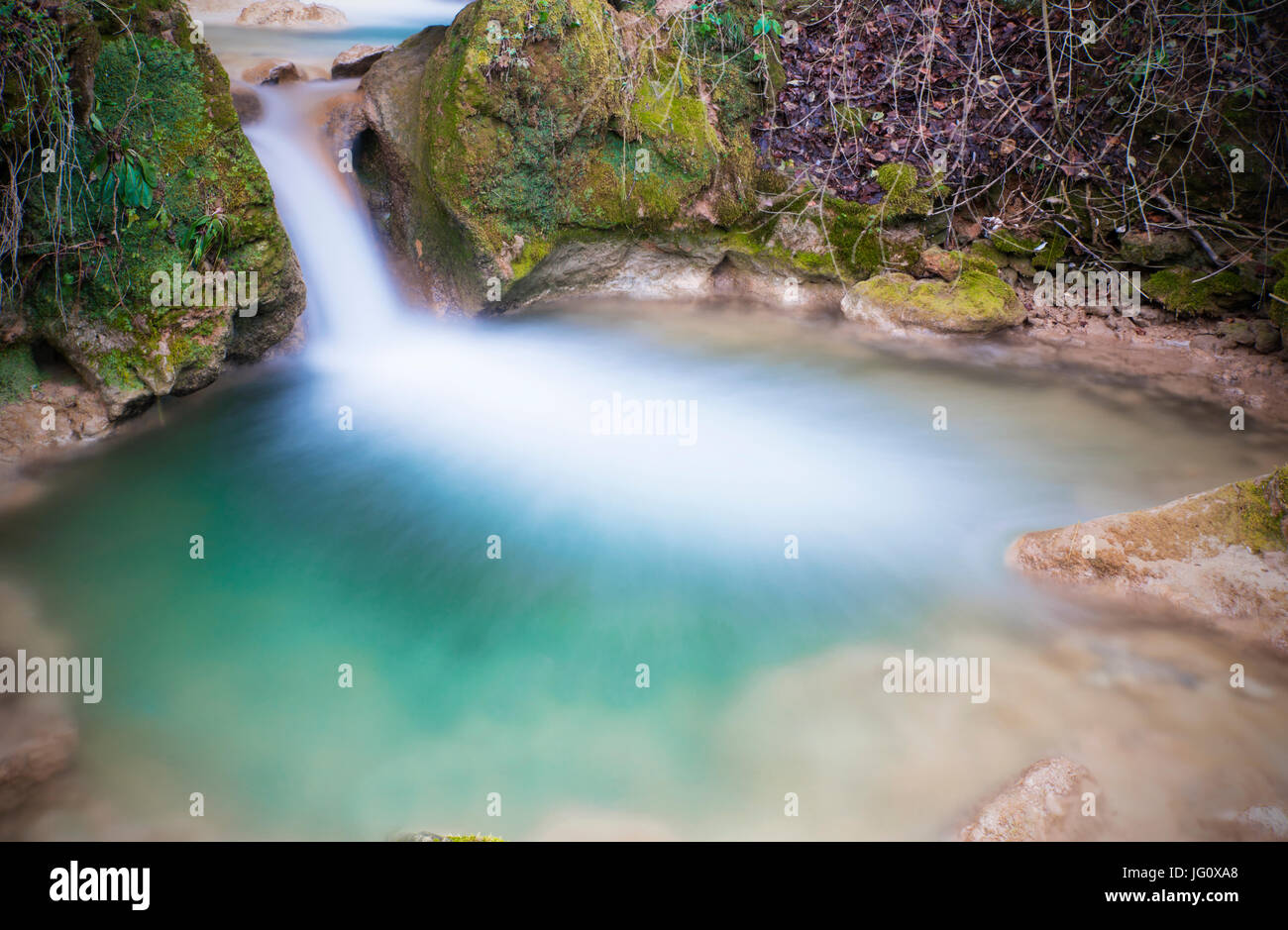 Waterfall among trees and moss covered rocks Stock Photo - Alamy
