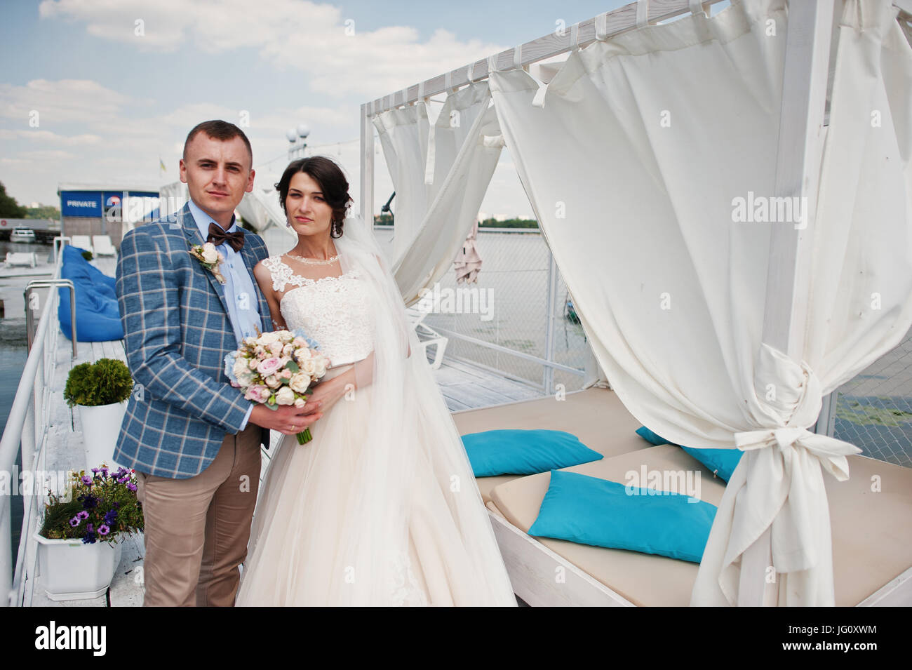 Beautiful bride and handsome groom standing next to the gazebo on their ...