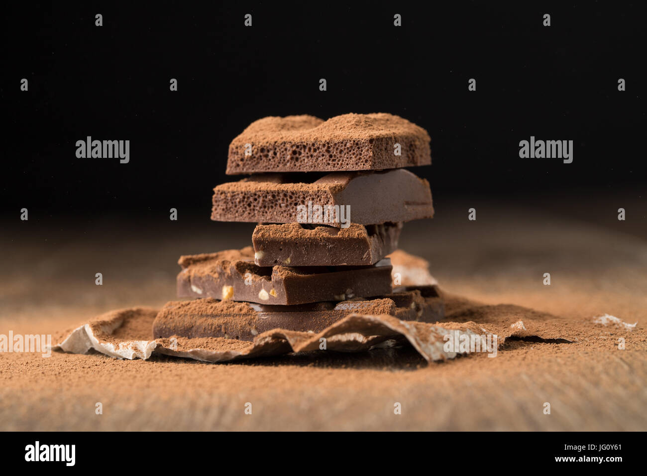 Milk chocolate on wooden table Stock Photo - Alamy