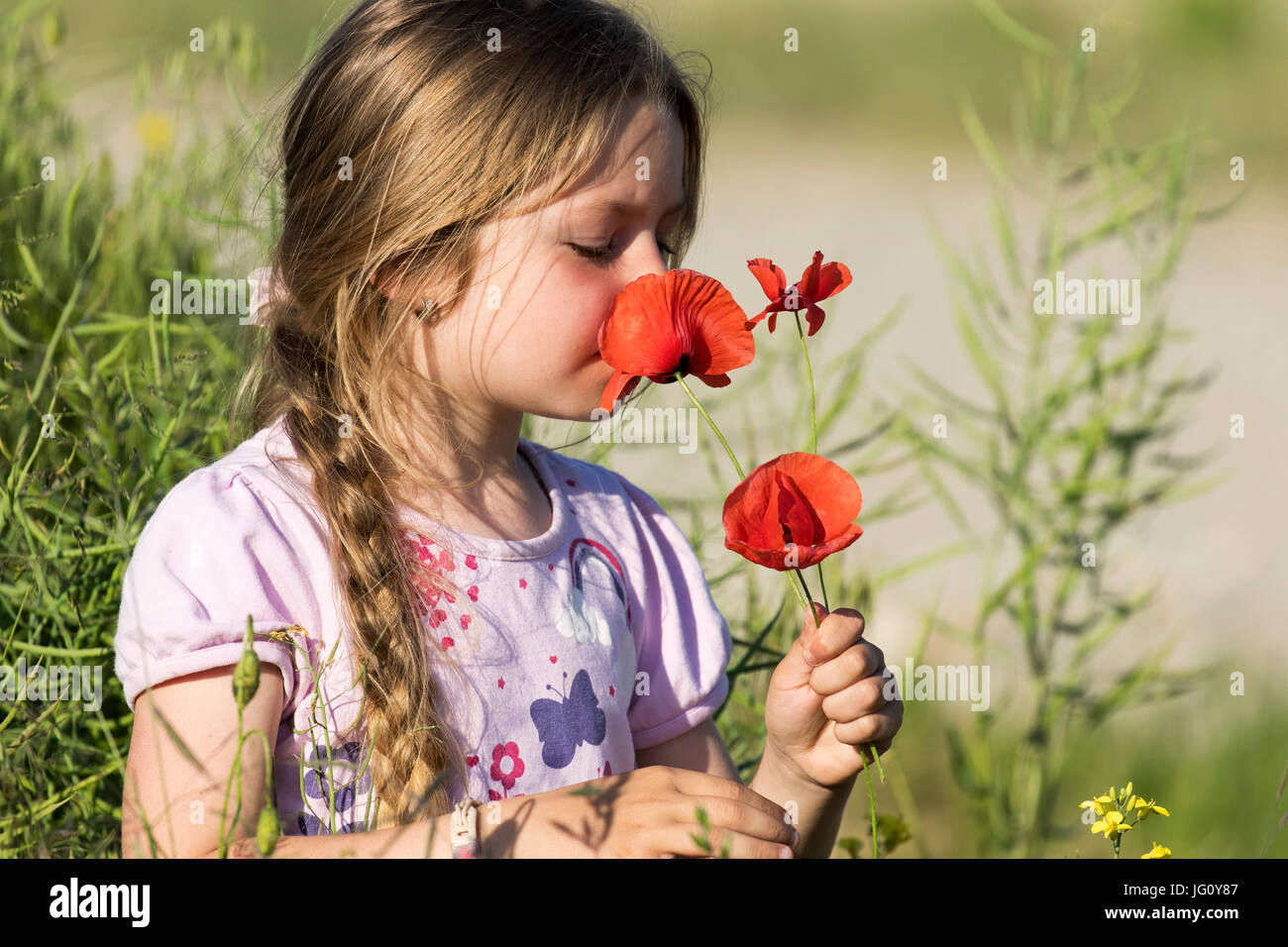 Girl with a poppy Stock Photo - Alamy