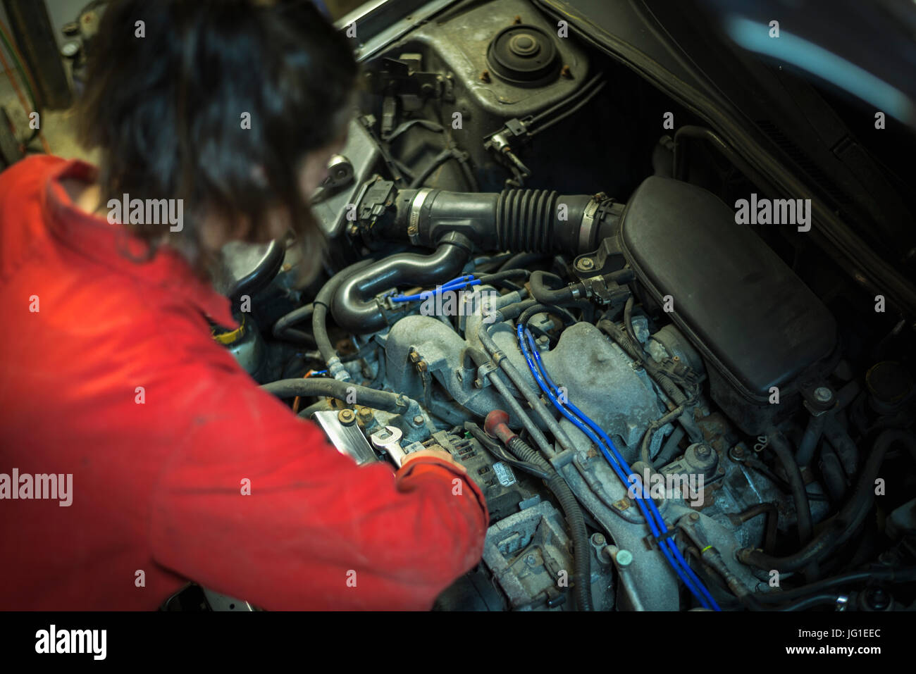 Female mechanic inspecting a car engine with wrench top down Stock ...