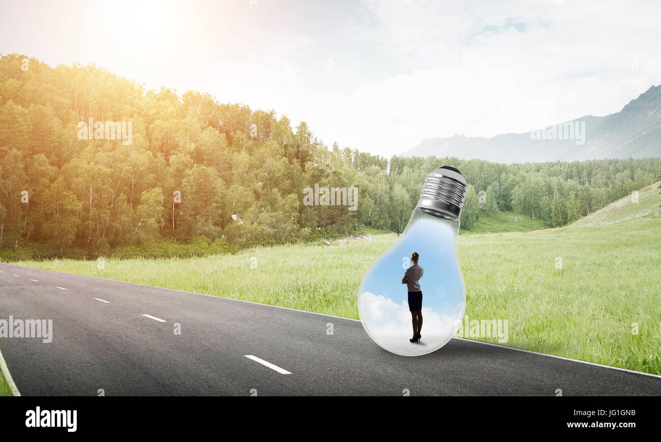 Young businesswoman trapped inside of light bulb on asphalt road Stock ...
