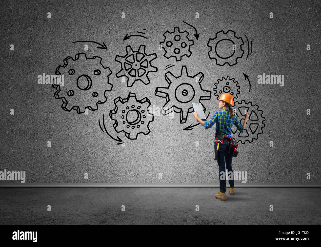 Back view of engineer woman in hardhat and sketched concept of teamwork ...