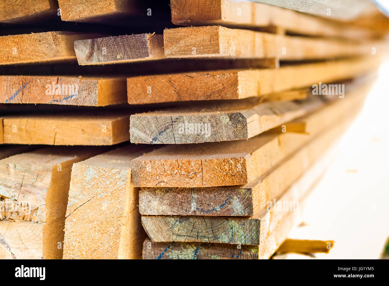Stack of building lumber at construction site with narrow depth of ...