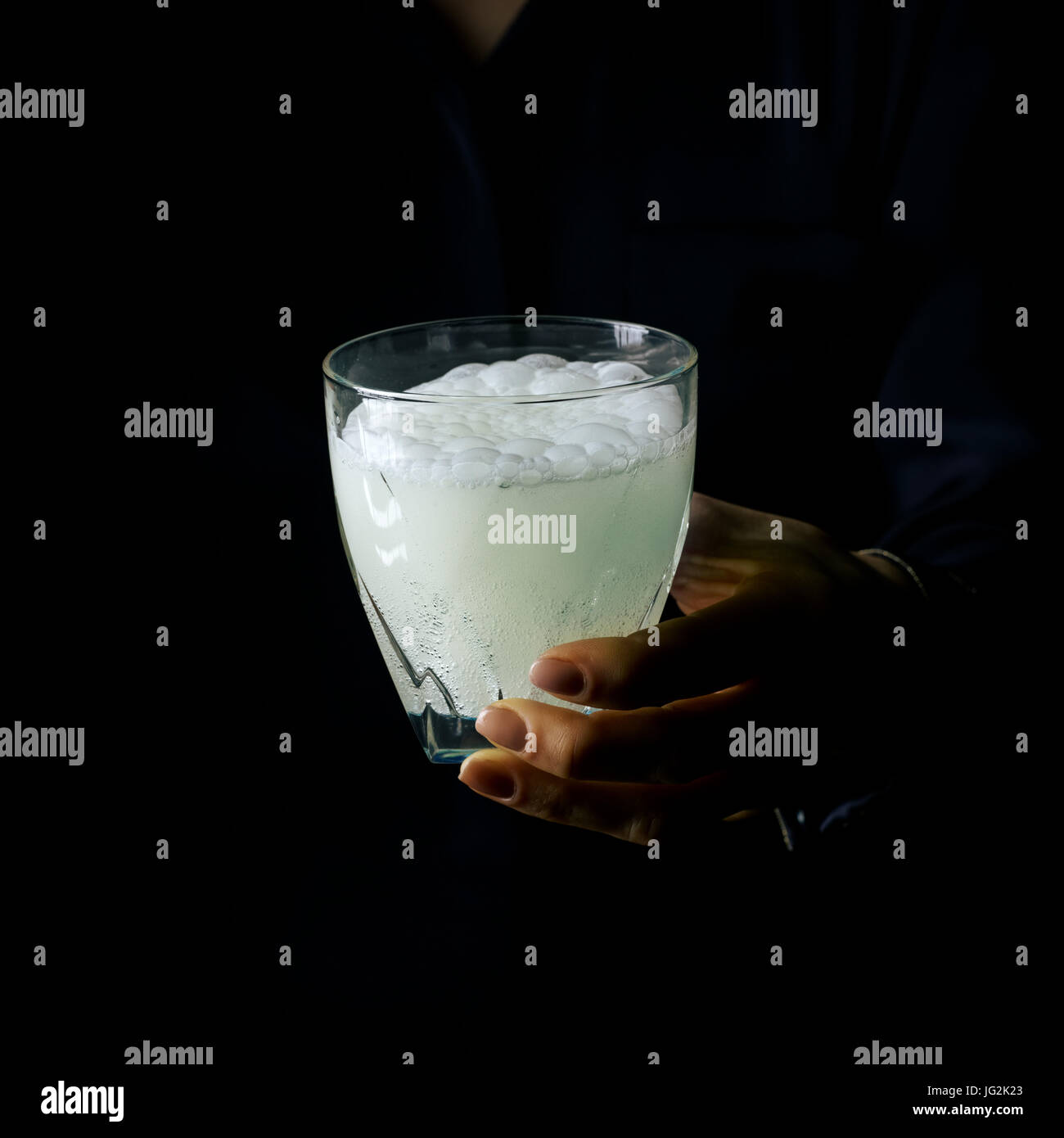 Black Mania. woman hand isolated on black background showing glass of ...
