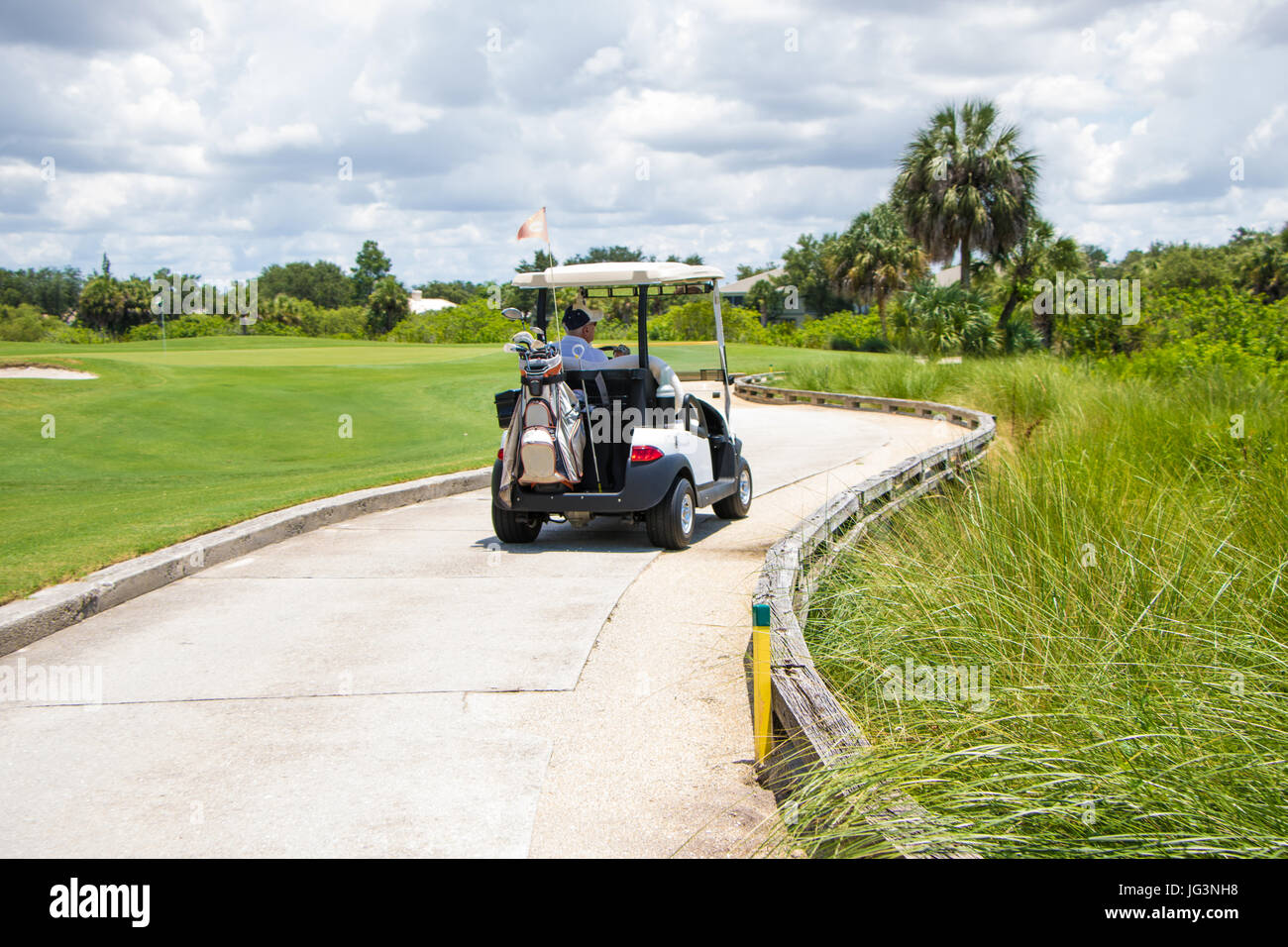 Man Driving Golf Cart on Path Stock Photo - Alamy