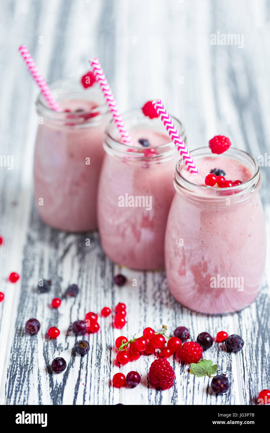 Row of milkshake jars with berries aside Stock Photo - Alamy