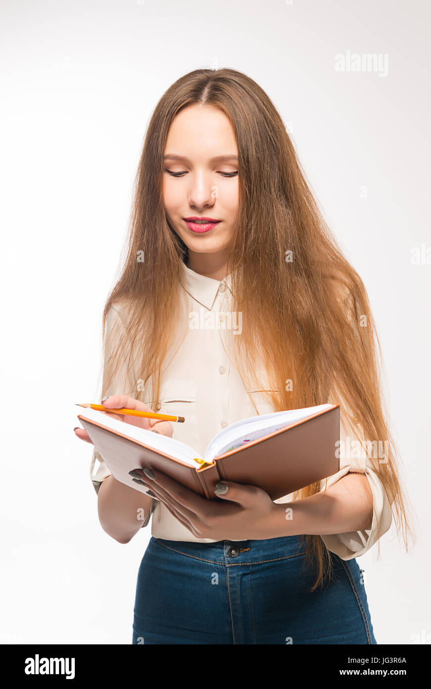 Girl with pencil and book in hands Stock Photo - Alamy